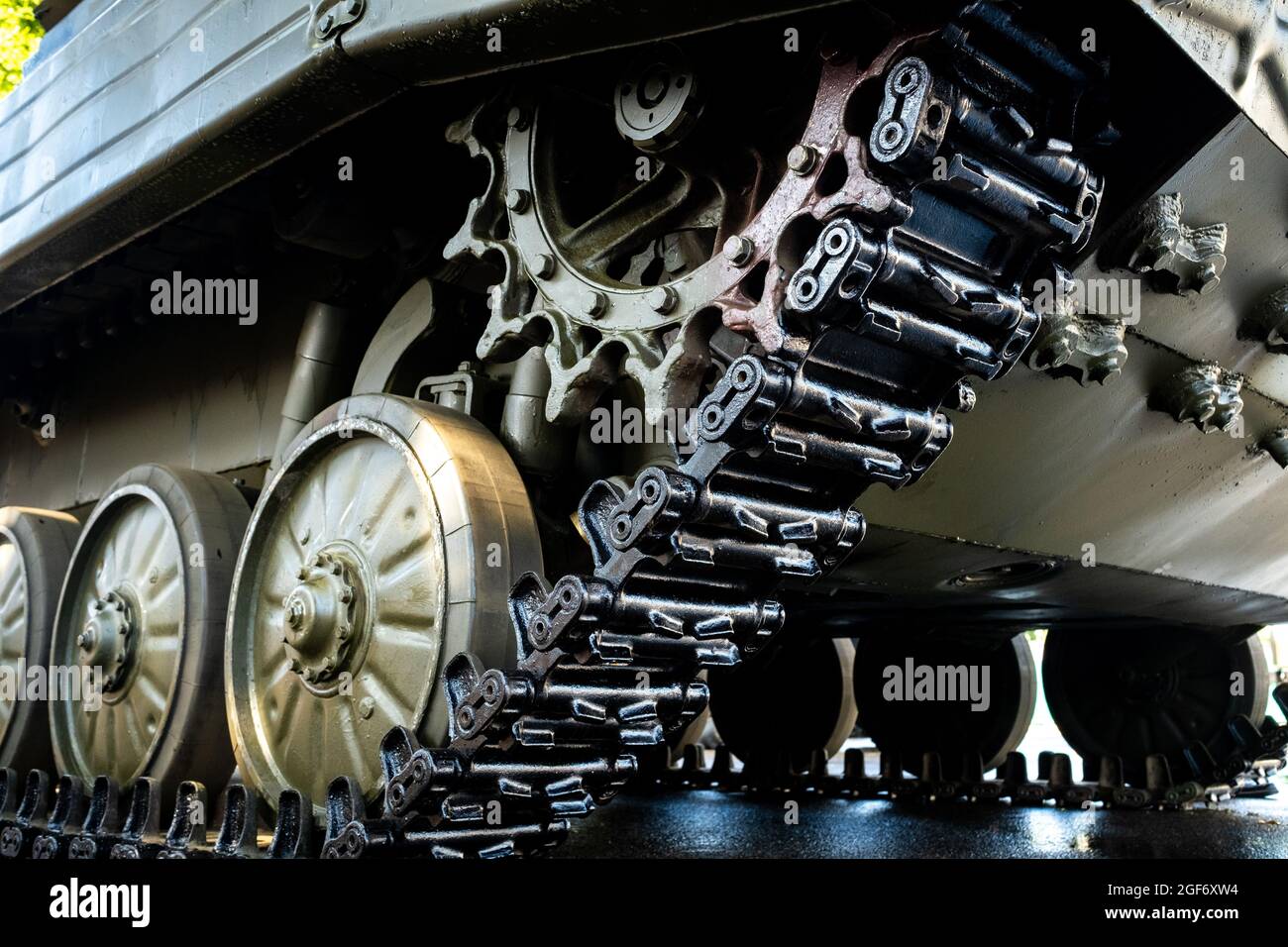 Tracked armor close-up. Black link tracks and large rubberized rollers ...