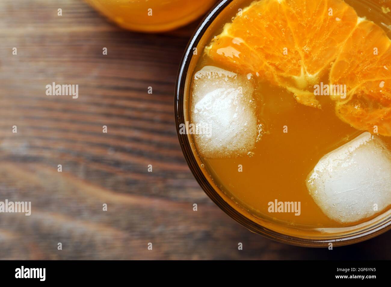 Glasses of orange juice with ice blocks and fruit slice on wooden ...