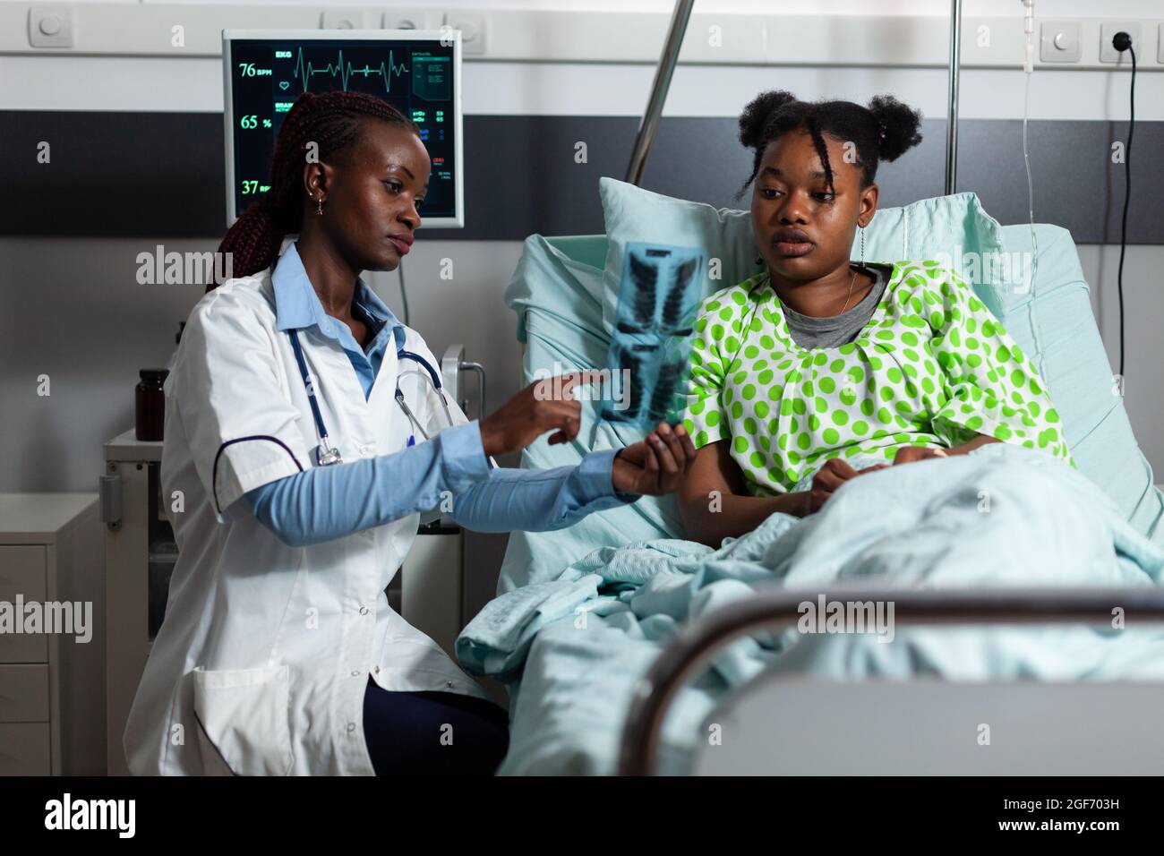 Woman with doctor occupation holding x ray results with patient in ...