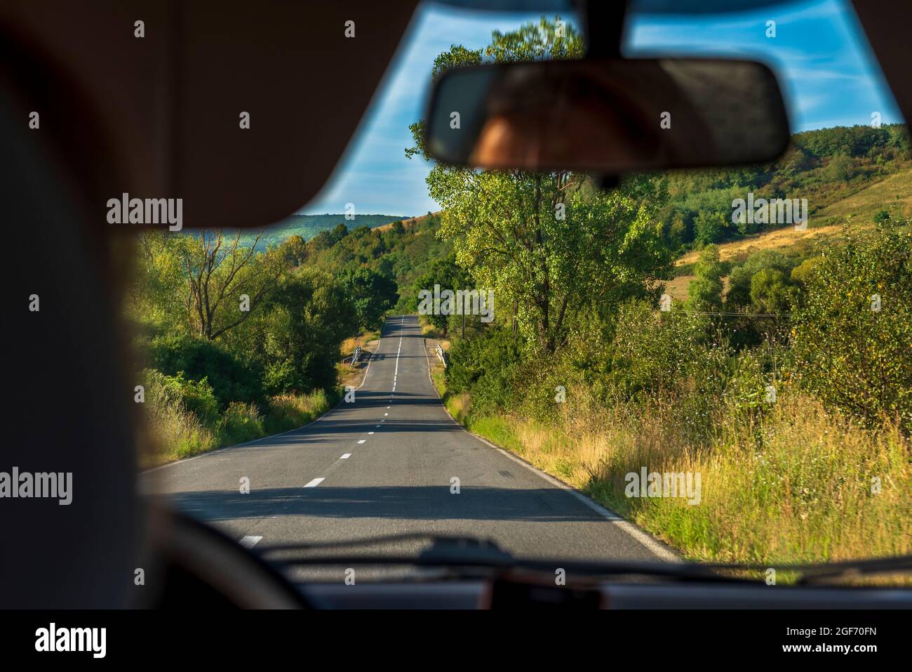 Traffic in the sun viewed from a car as blurred image with a long road ...