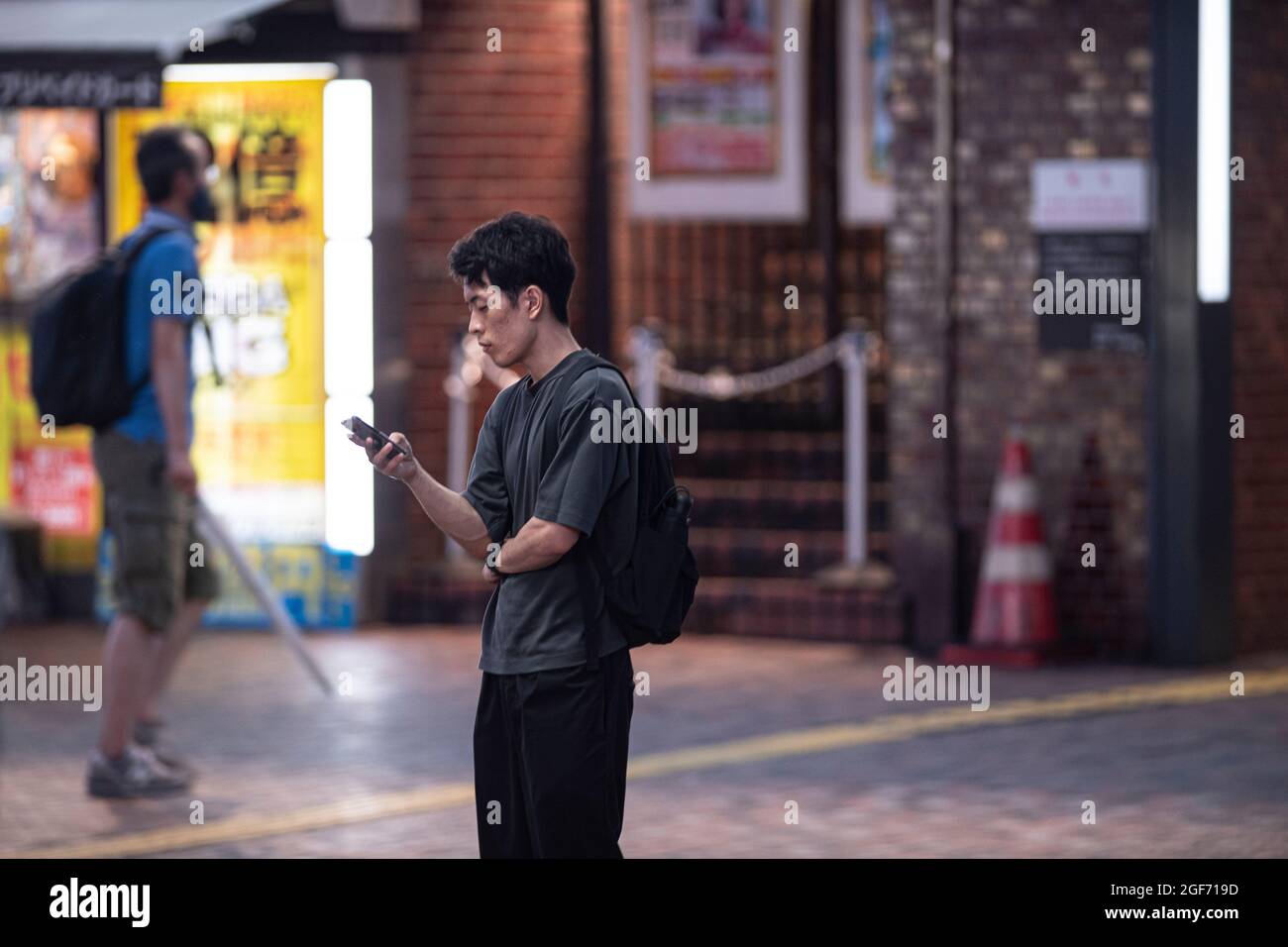 People on the street of Tokyo looking at their mobile phone and their ...