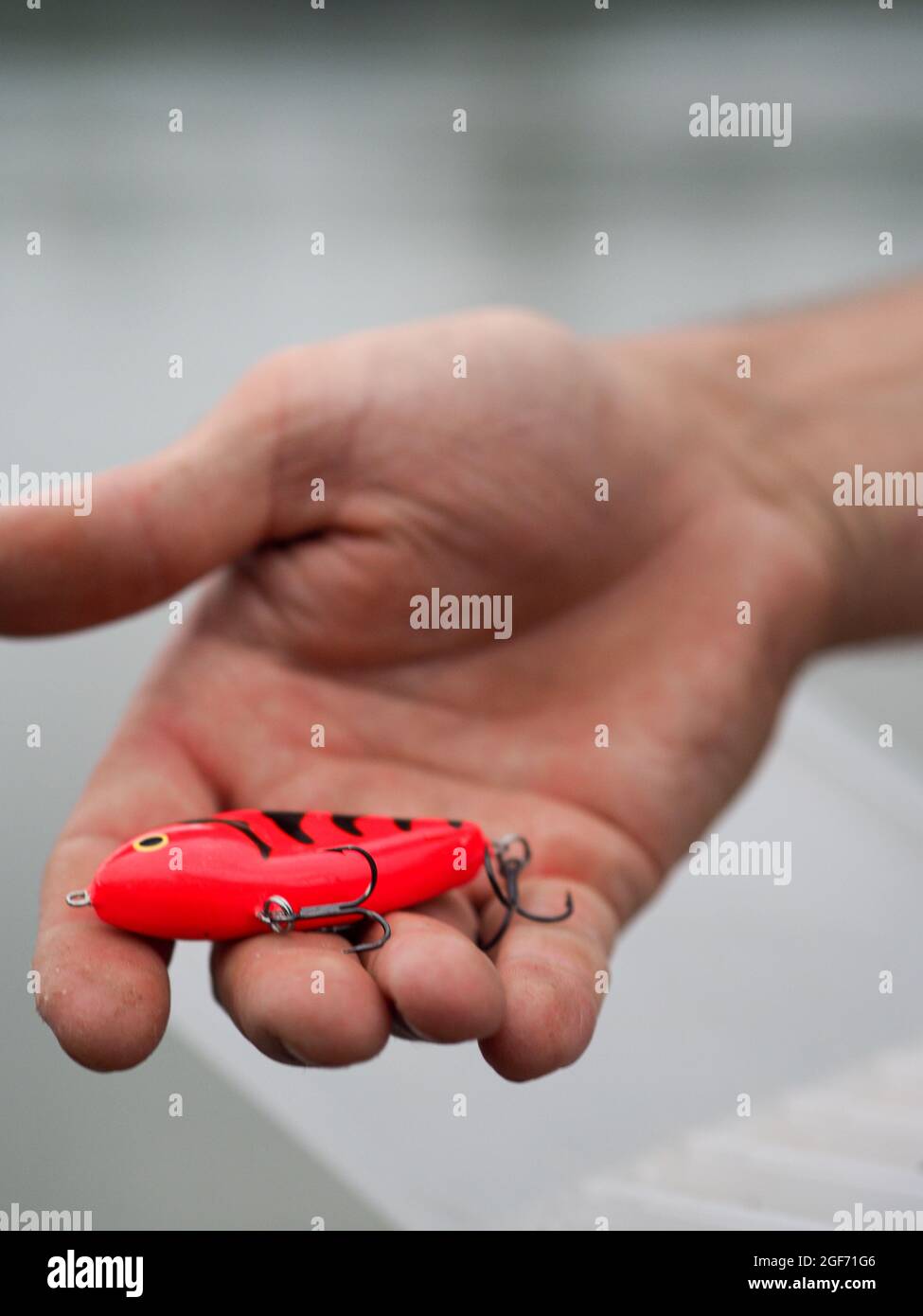 Fisherman hand holding a fishing tackle Stock Photo - Alamy