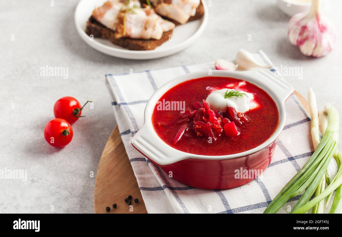 Delicious fresh red borscht, dark bread with lard and salt on kitchen ...