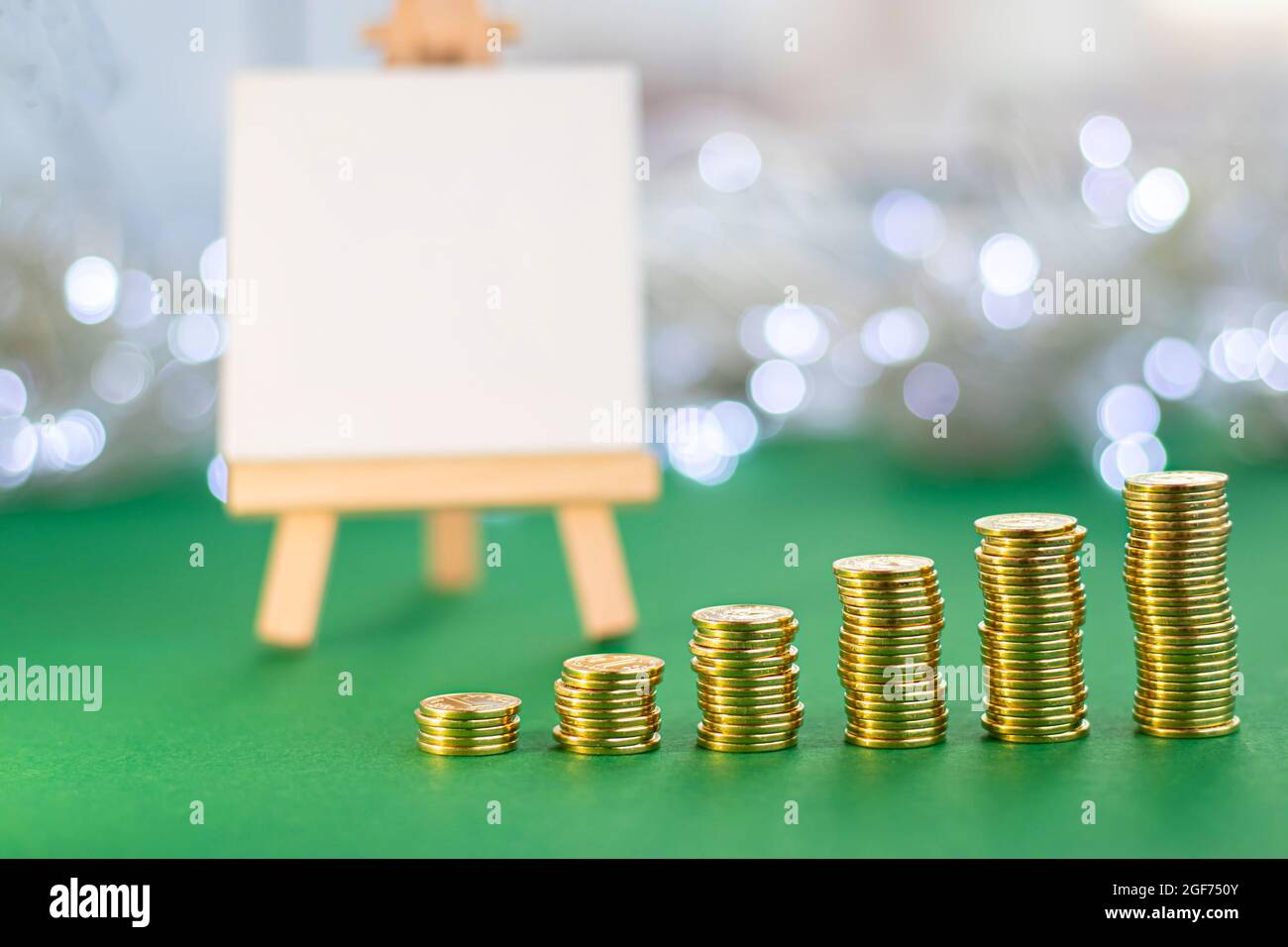 golden stacks of coins ascending on a green background with bokeh and ...