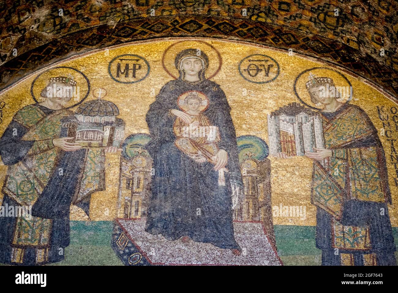 A gold mosaic of the Virgin Mary with baby Jesus, receiving gifts. The ...