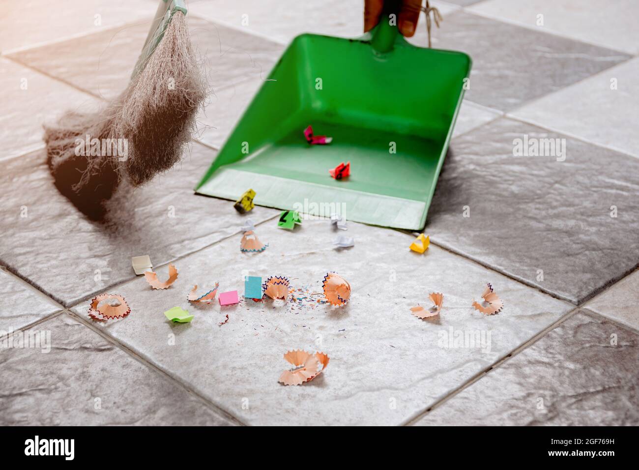 Sweep up scraps of paper and dust on tile floors with a broom and a ...