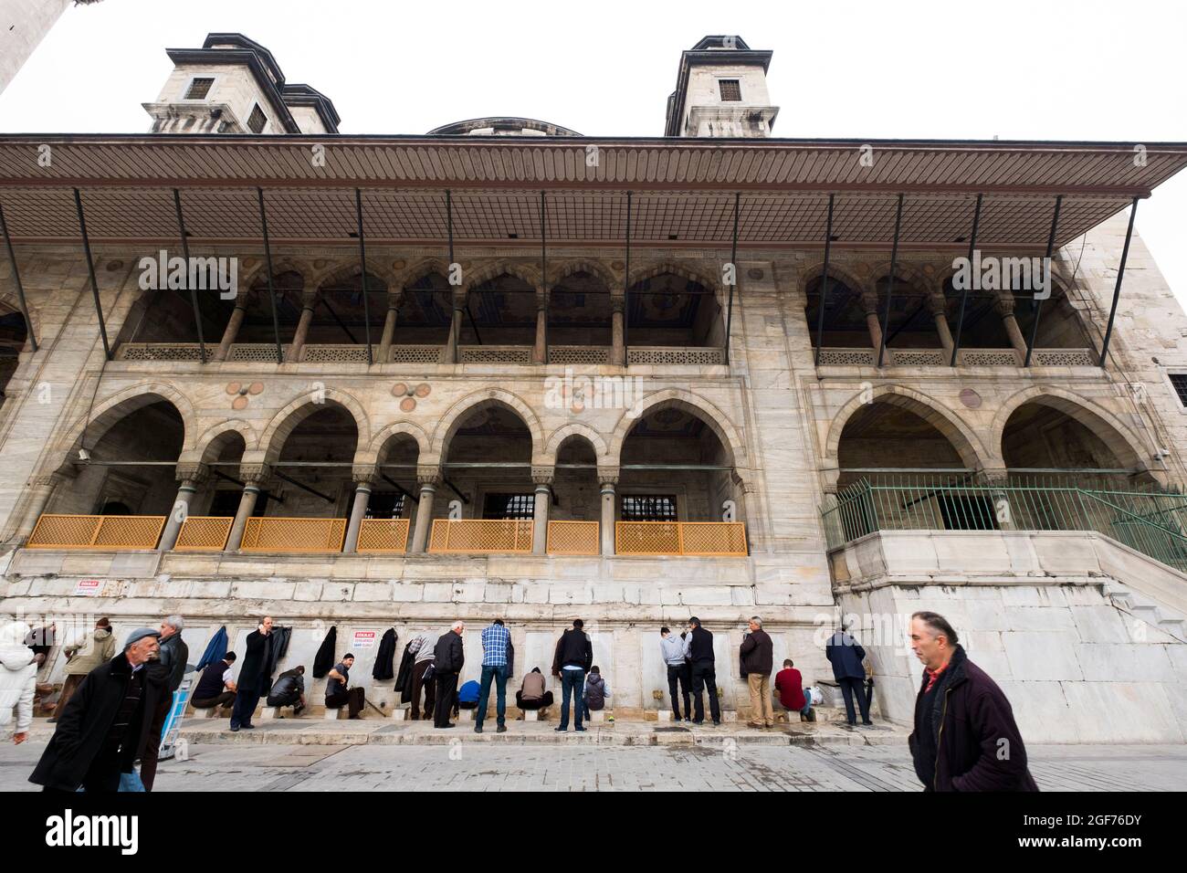 Men washing their feet before entering the New Valide Sultan mosque. In ...