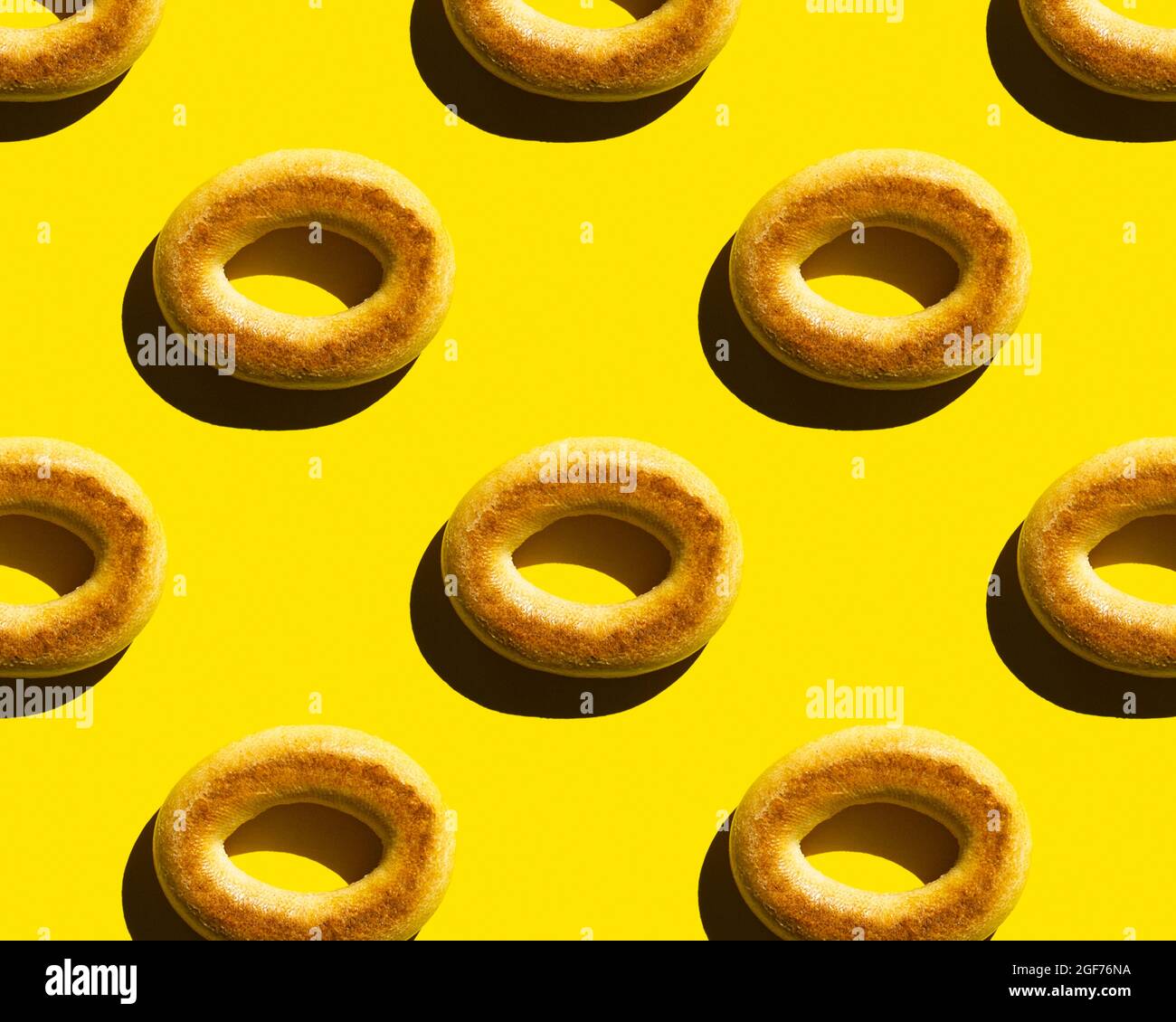 bagel pattern on yellow background Stock Photo - Alamy