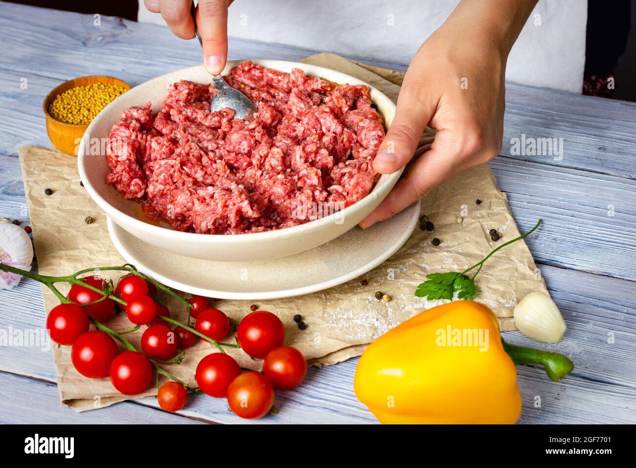The process of cooking cutlets on a light wooden table from minced pork ...