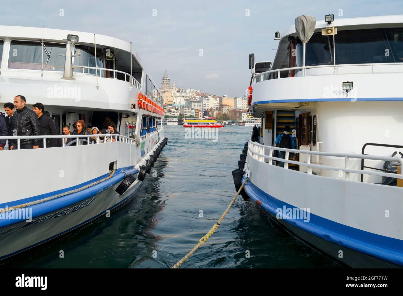 Two commuter ferry boats docked at a pier on the Golden Horn with the ...