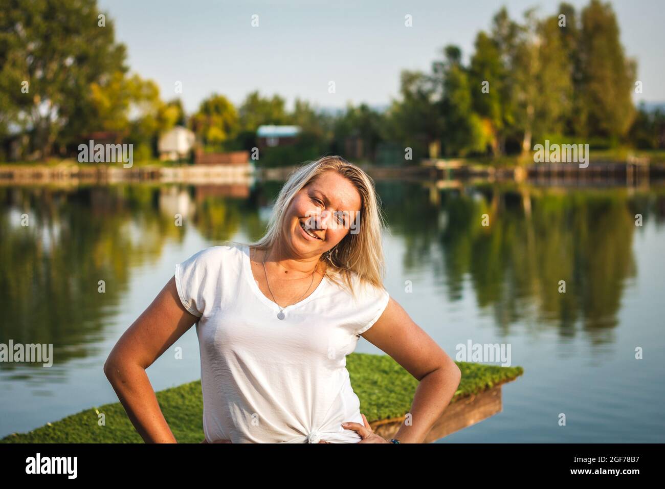 Happy smiling plus size woman at lake in tourist resort. Enjoyment of ...