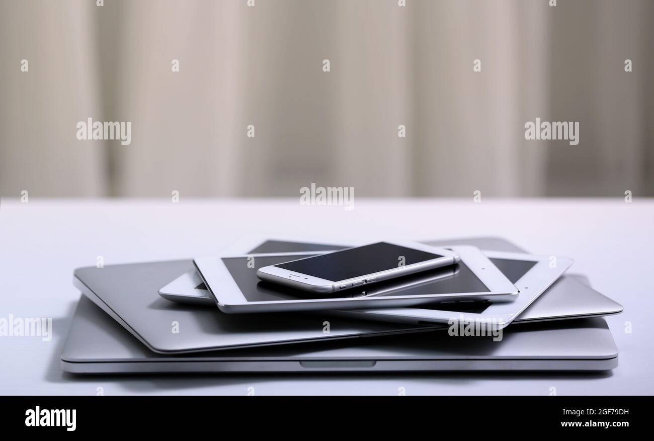 Stack of electronic devices on a white desk Stock Photo - Alamy