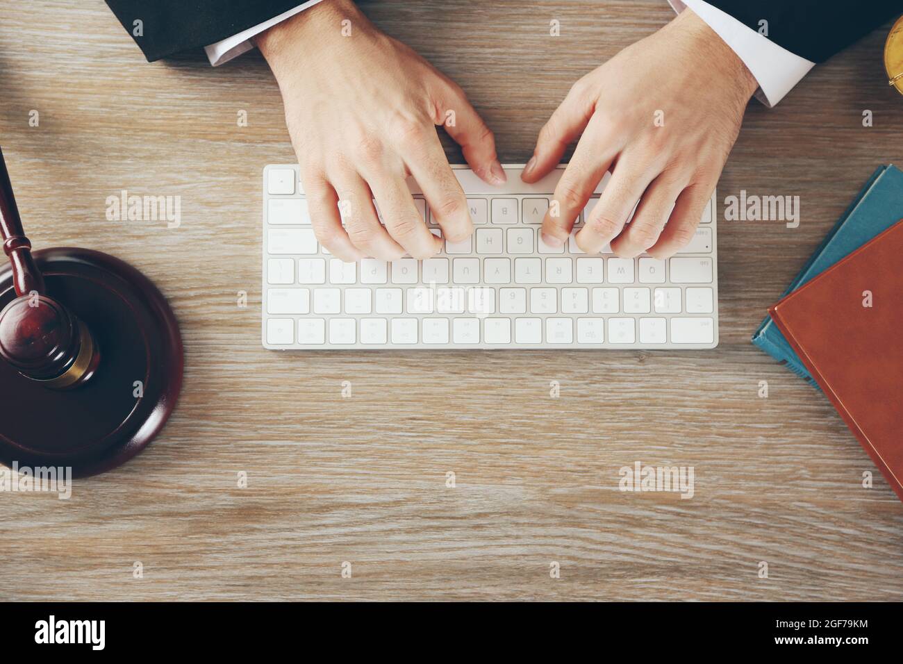 Judge hands working with computer keyboard with books and gavel at ...