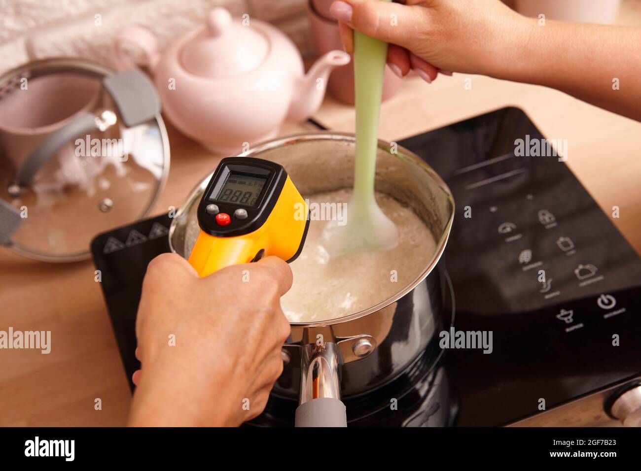 Measuring temperature of sweet syrup. Confectioner making sweets in the ...