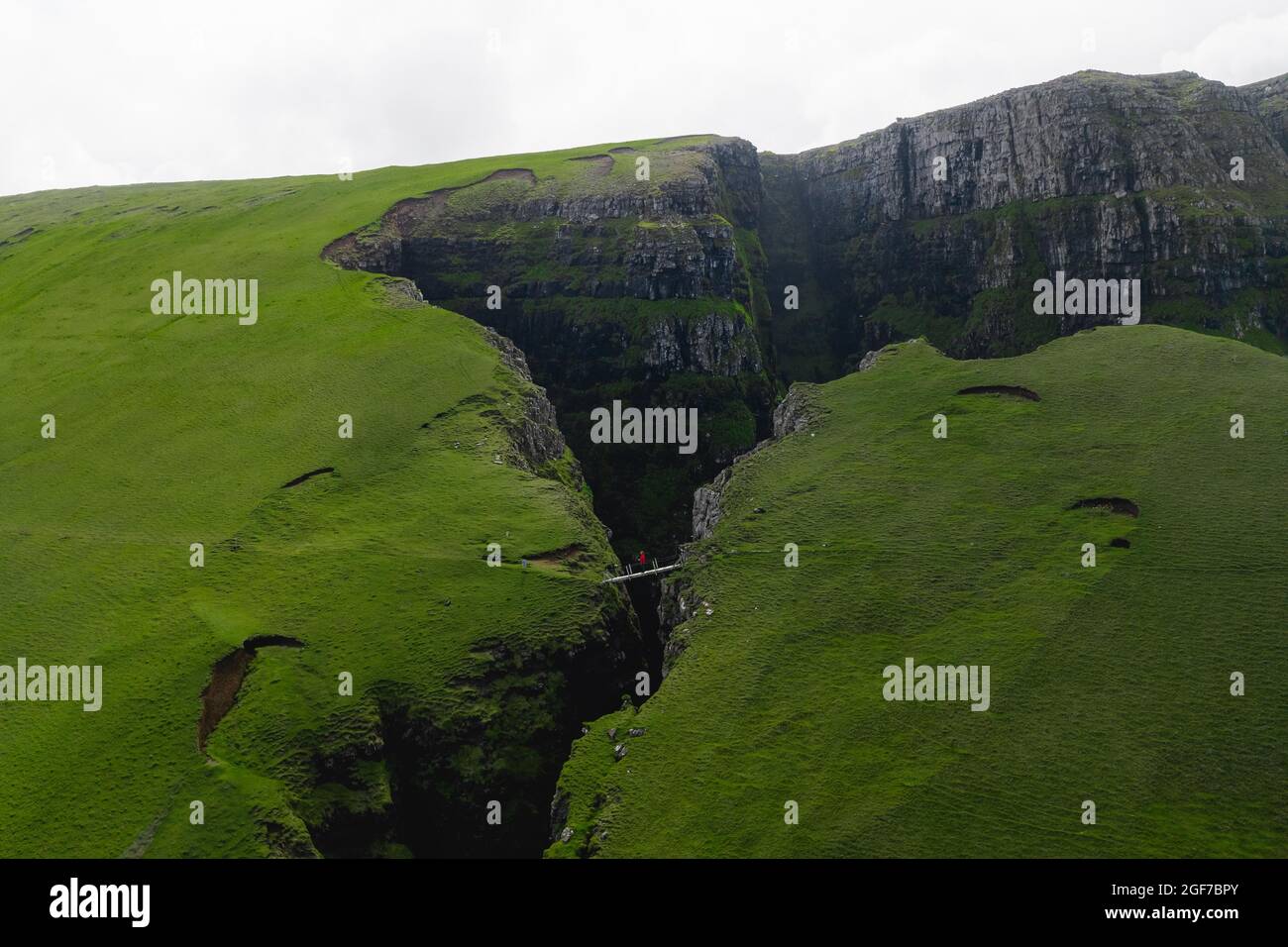 Aerial view, Asmundarstakkur cliff with person on bridge, Sandvik ...