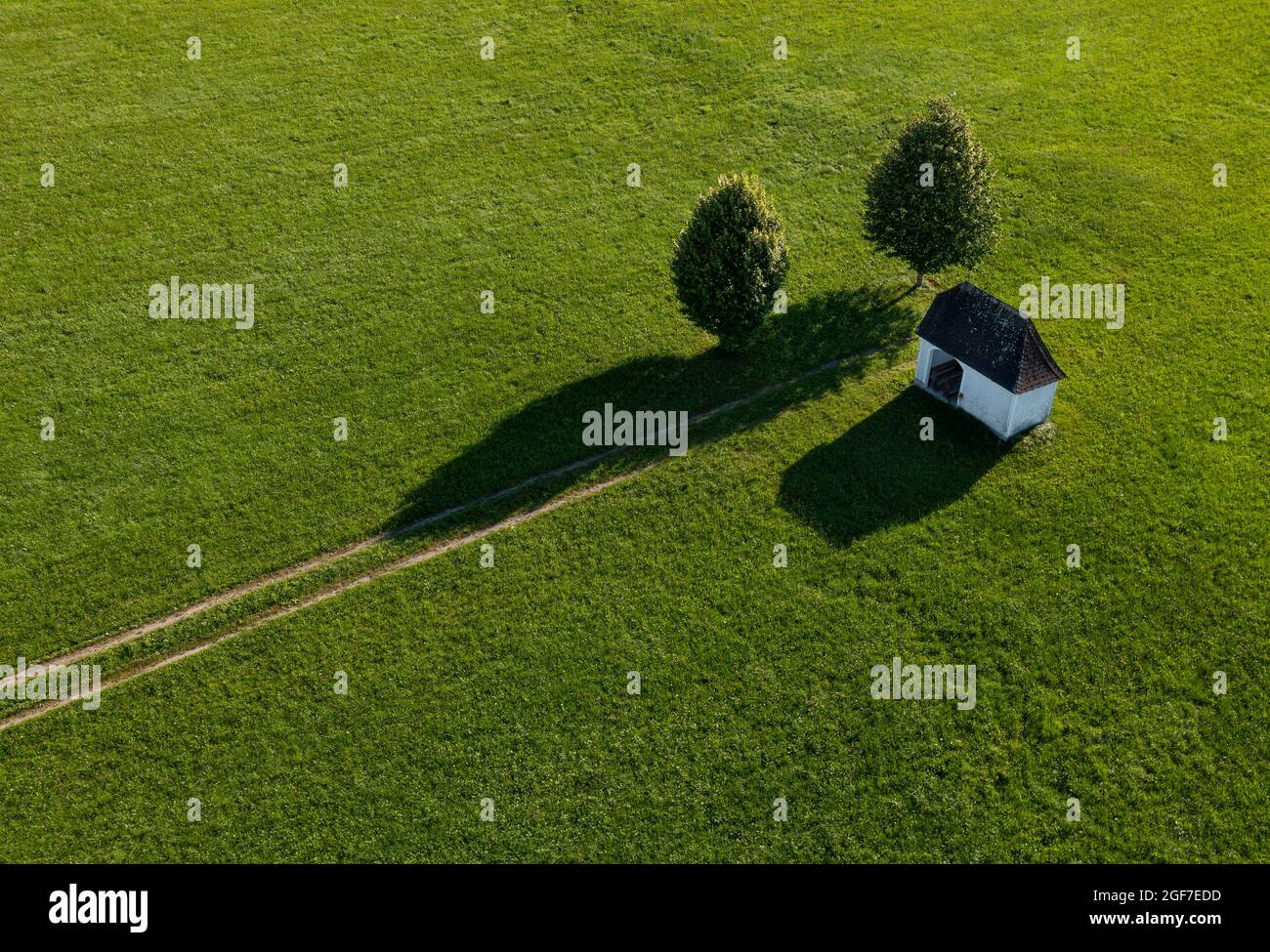 Drone image, Small field chapel between two deciduous trees ...