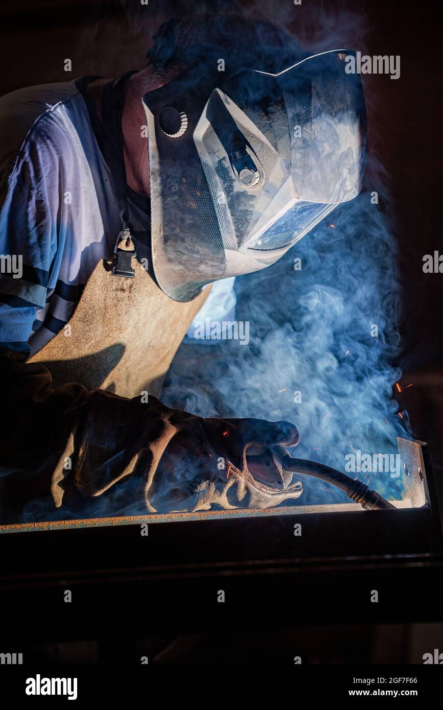 The welder works with a metal profile. Assembly of metal structures in ...