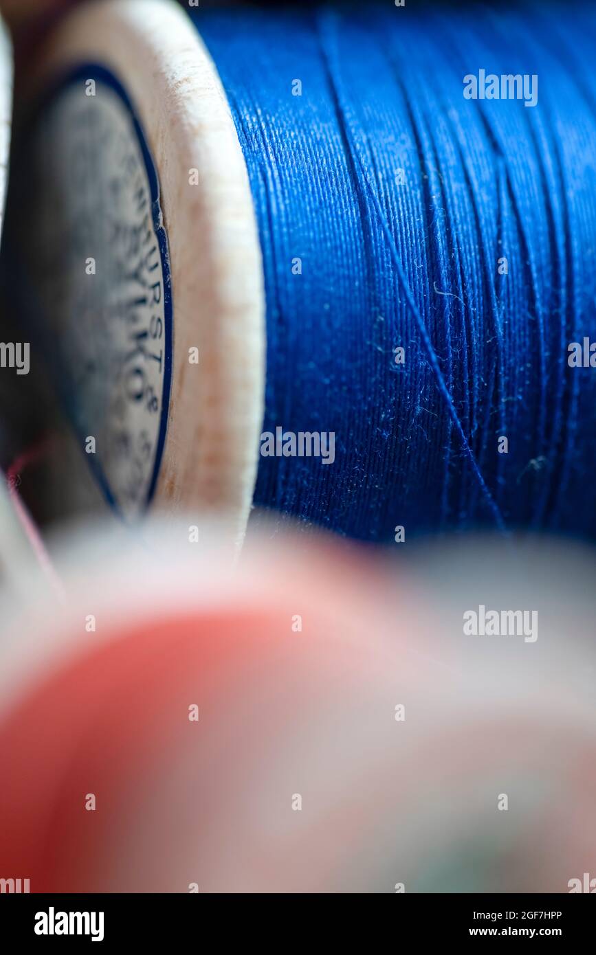 View of vibrant colourful cotton on small reels in a vintage sewing box ...