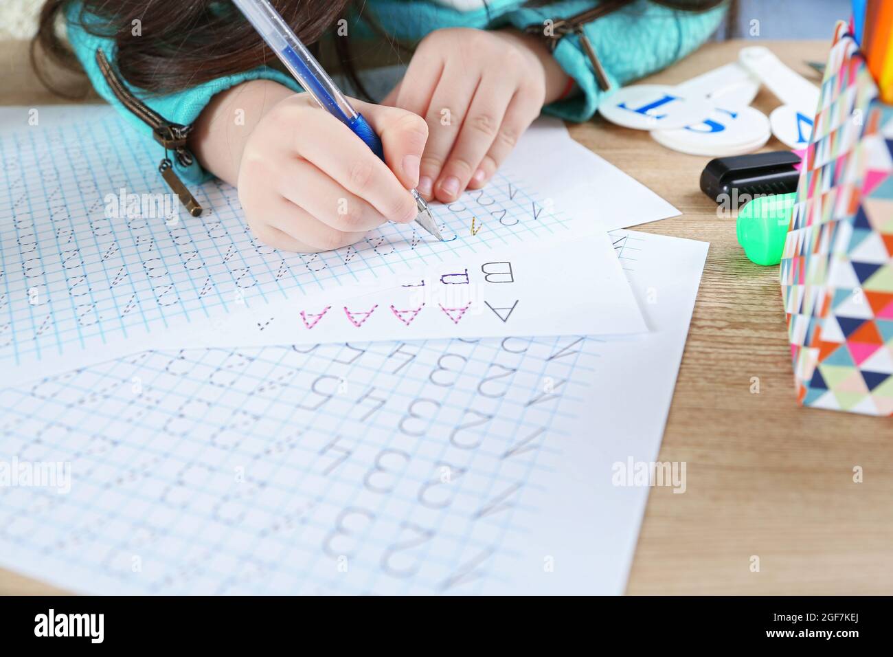 Little girl learning to write digits at the table Stock Photo - Alamy