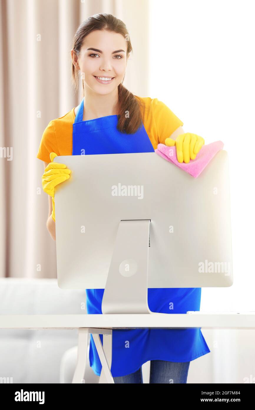 Young woman cleaning computer monitor at workplace in the office Stock ...