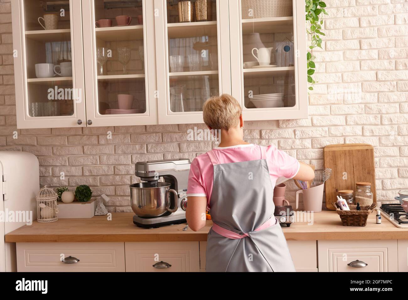 Woman confectioner making sweets in the kitchen, back view Stock Photo ...