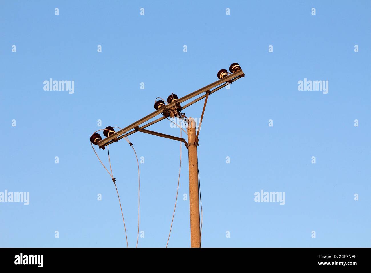 Narrow old dilapidated concrete electrical utility pole with damaged ...