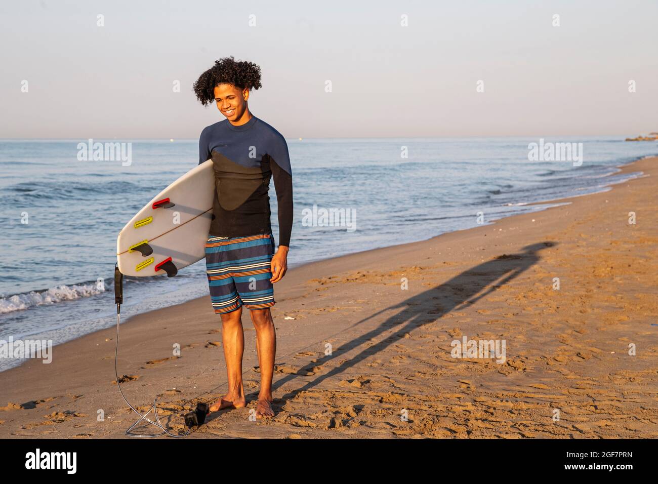 Photo of a smiling young surfer with a surfboard on the beach Stock ...