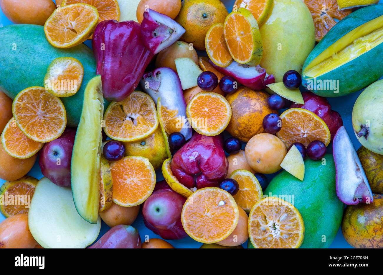 Variety of fresh assorted fruits on blue background. Assorted fruits ...