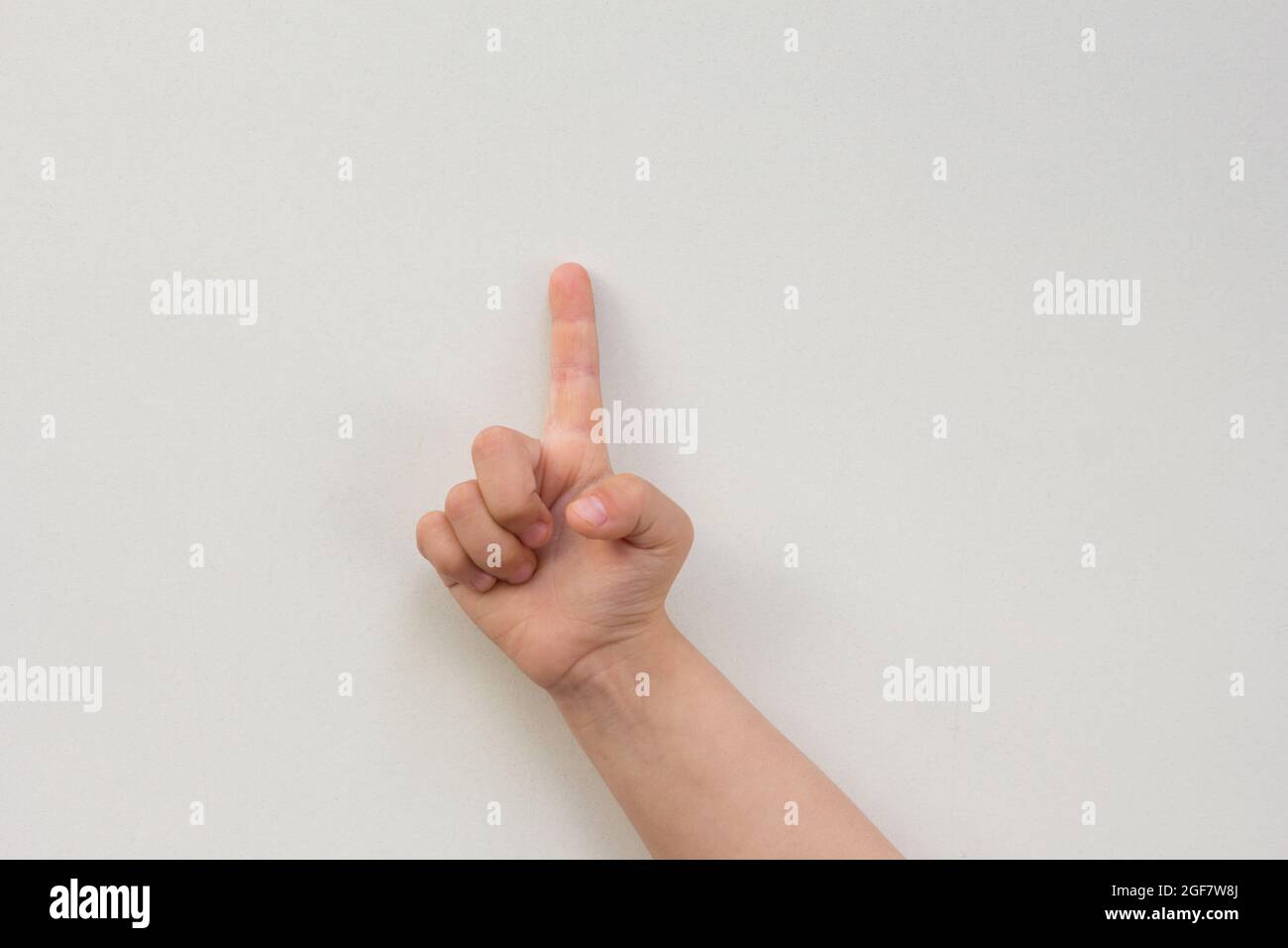 Top view of child hand showing one finger as number one on white ...