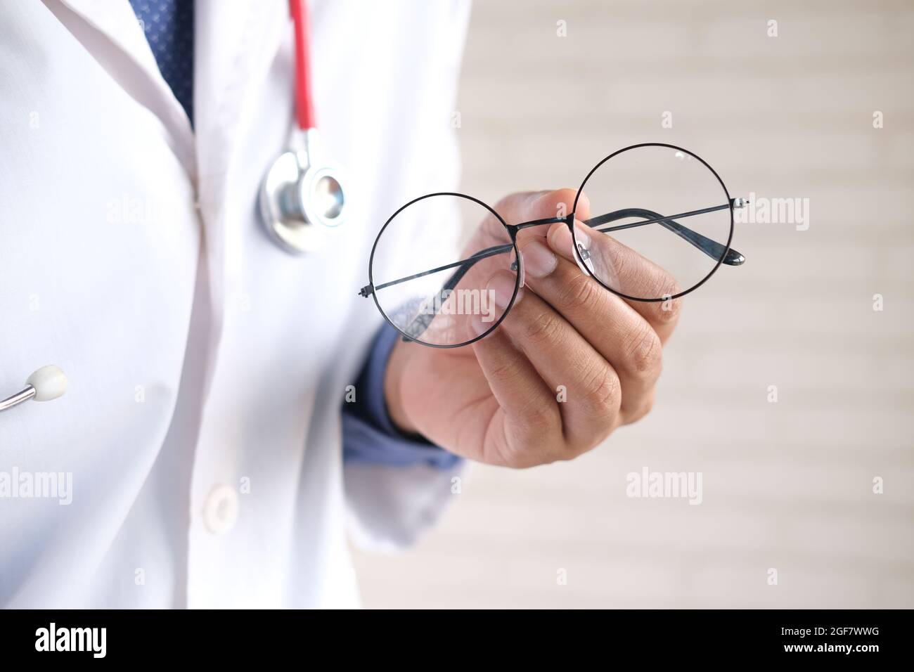 doctor hands giving pair of black glasses to patient Stock Photo - Alamy