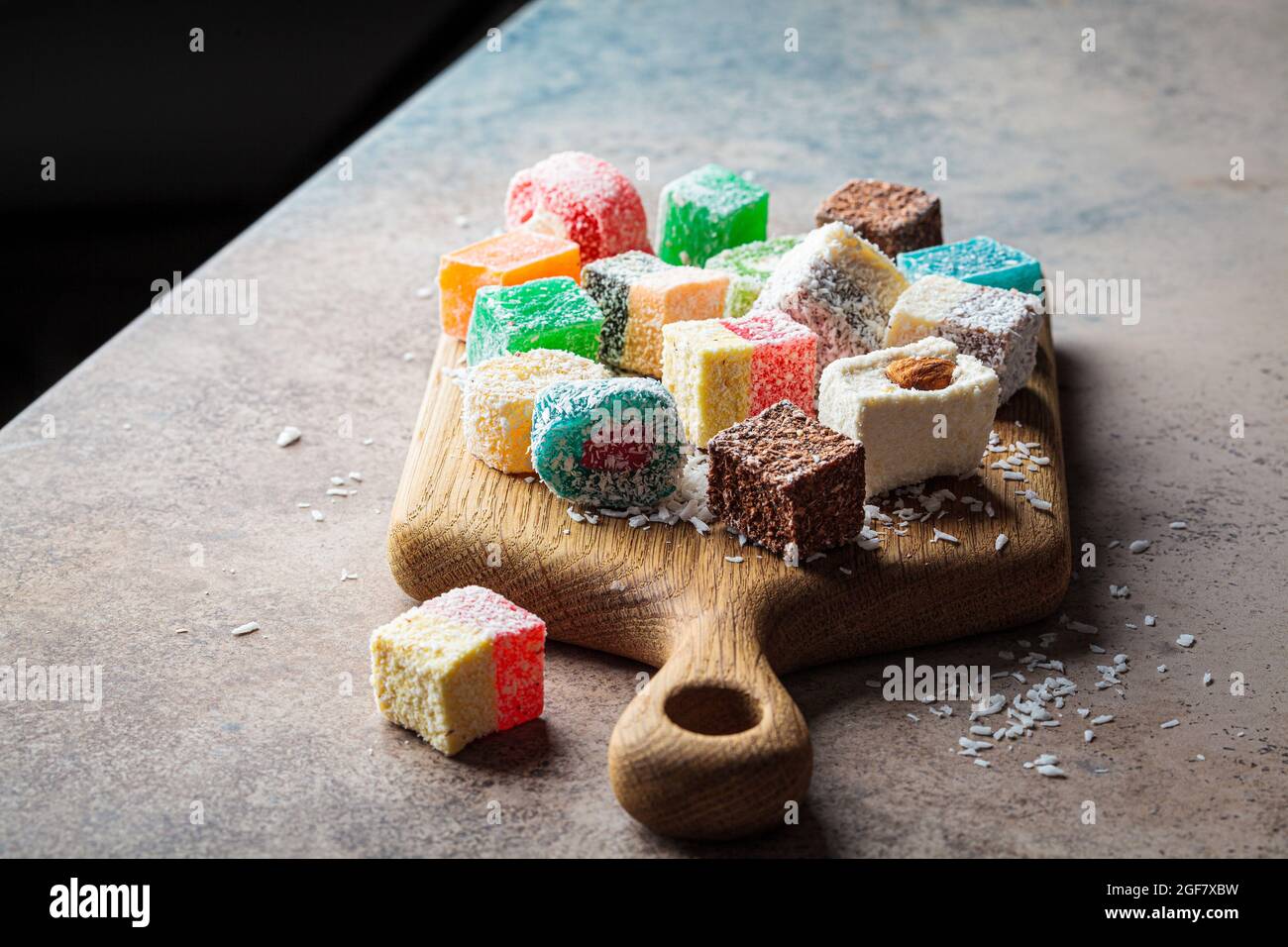 Turkish delight of different types on a wooden board, dark background ...