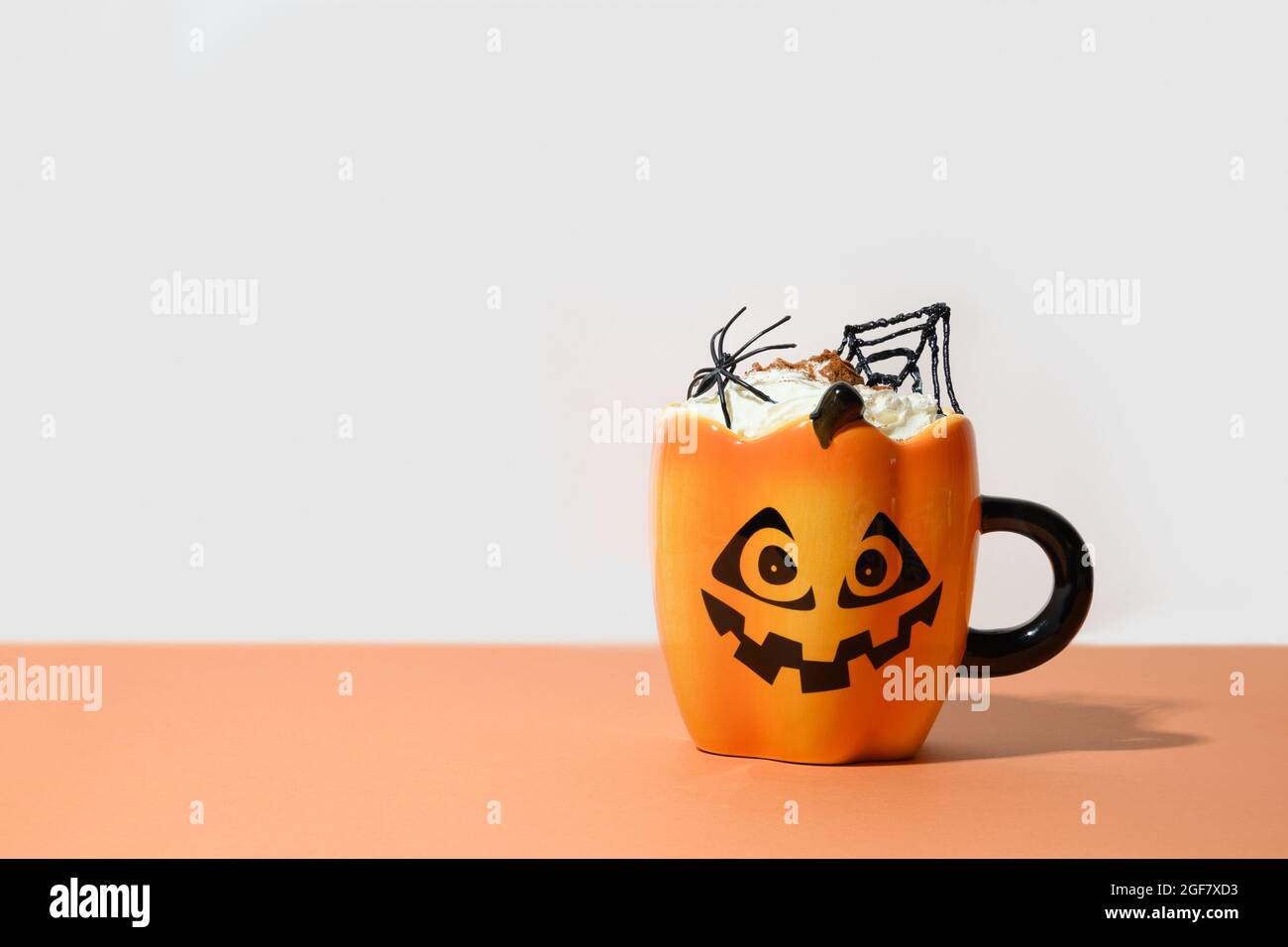 Halloween coffee latte in funny cup garnish whipped cream and spider ...