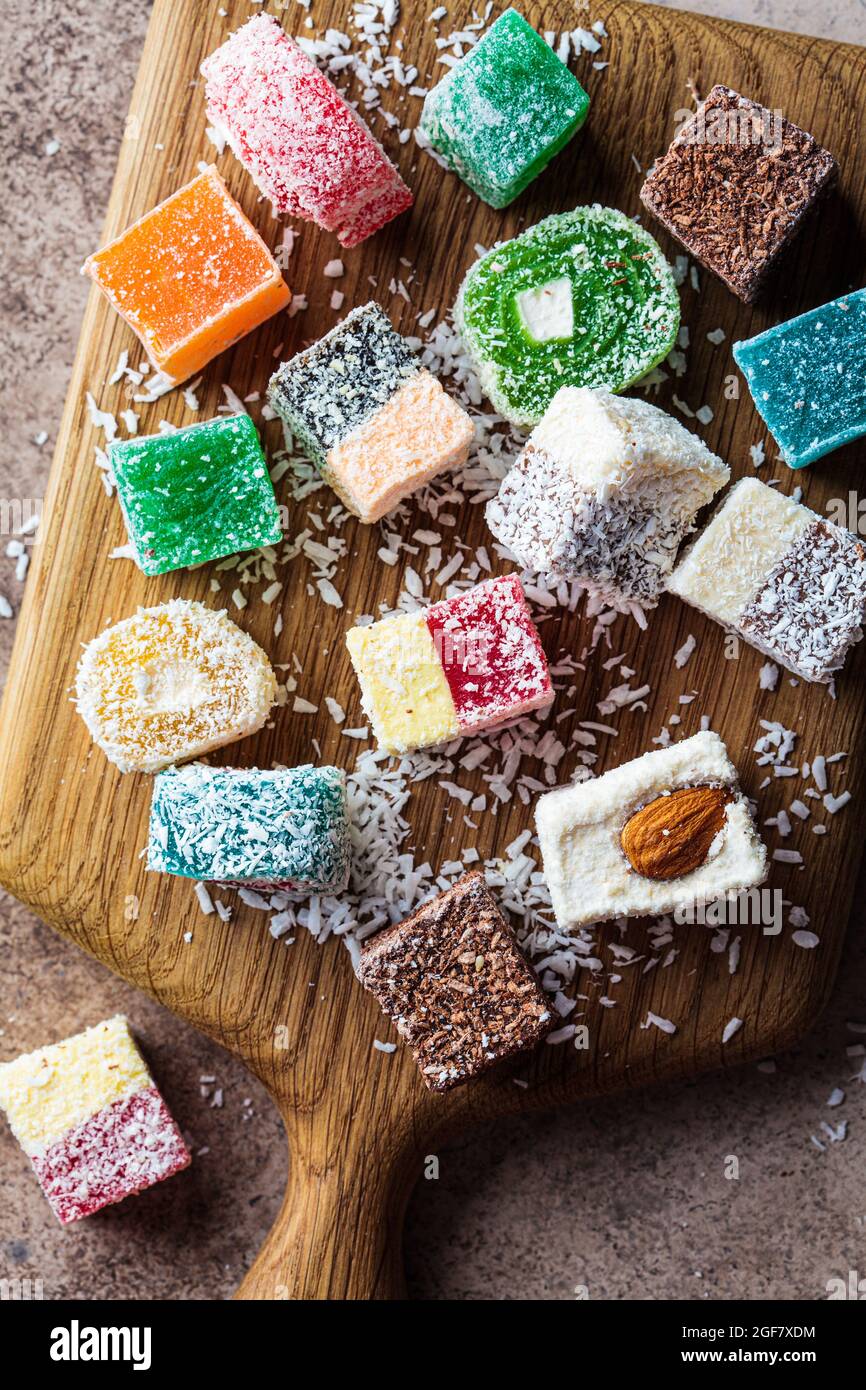 Turkish delight of different types on a wooden board, dark background ...