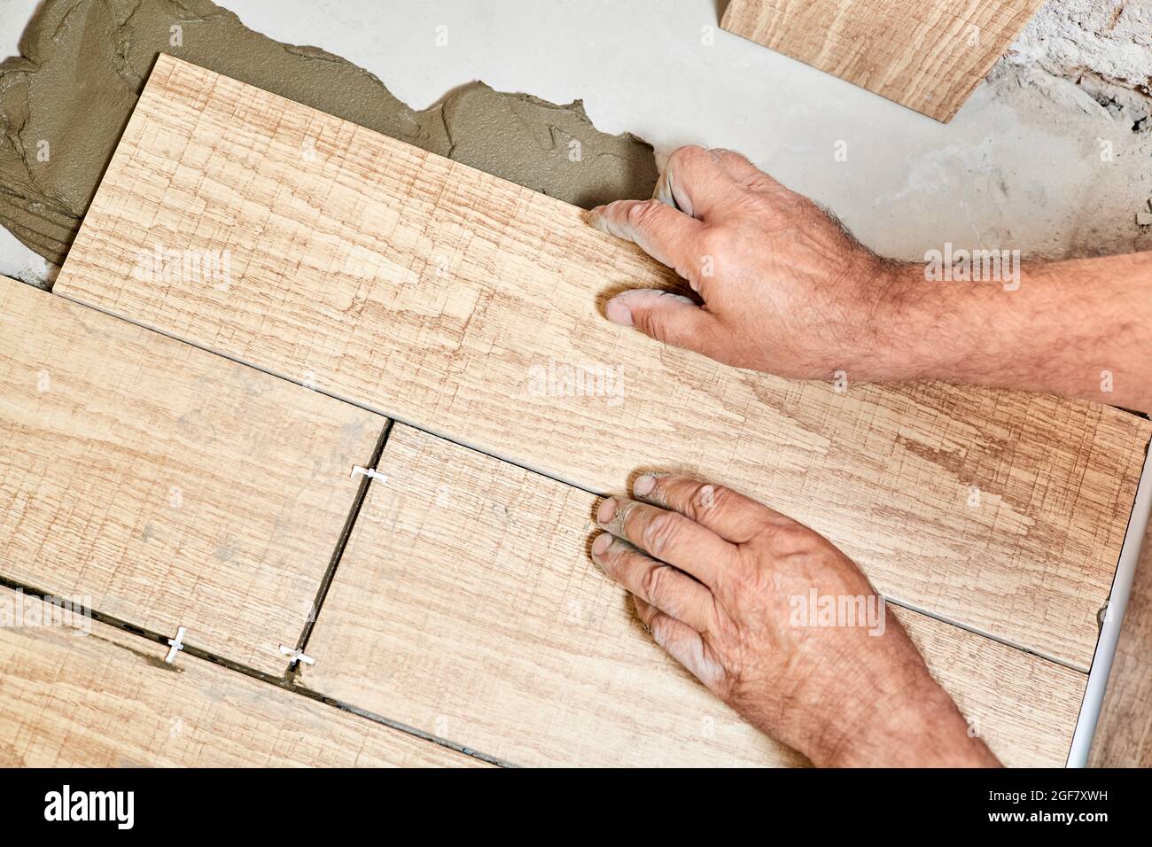 Man laying ceramic floor tiles. Close-up, selective focus Stock Photo ...