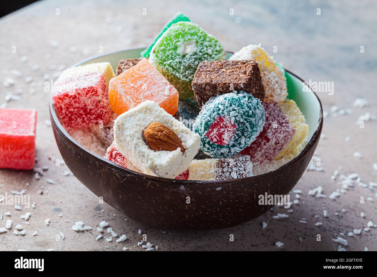 Turkish delight of different types in a coconut bowl, dark background ...