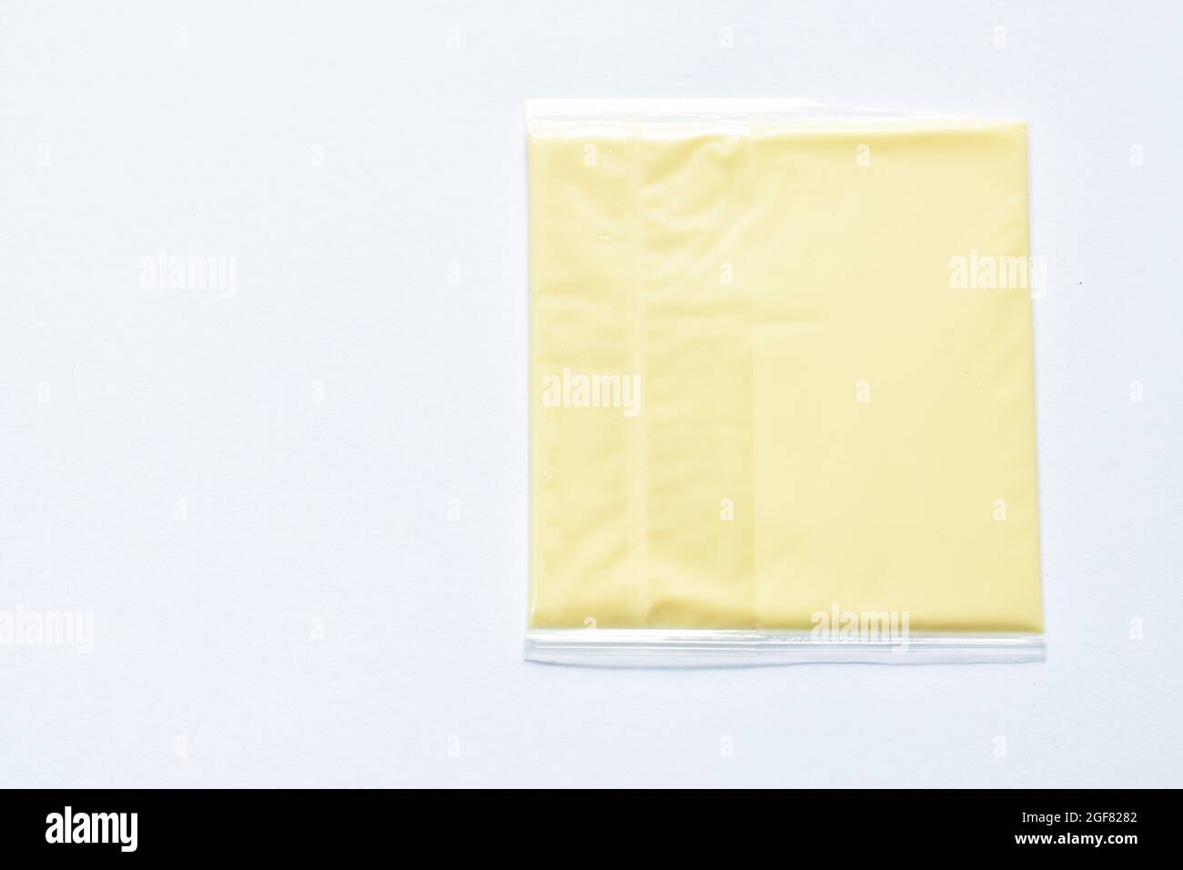 square cheese in clear plastic packing on white background Stock Photo ...