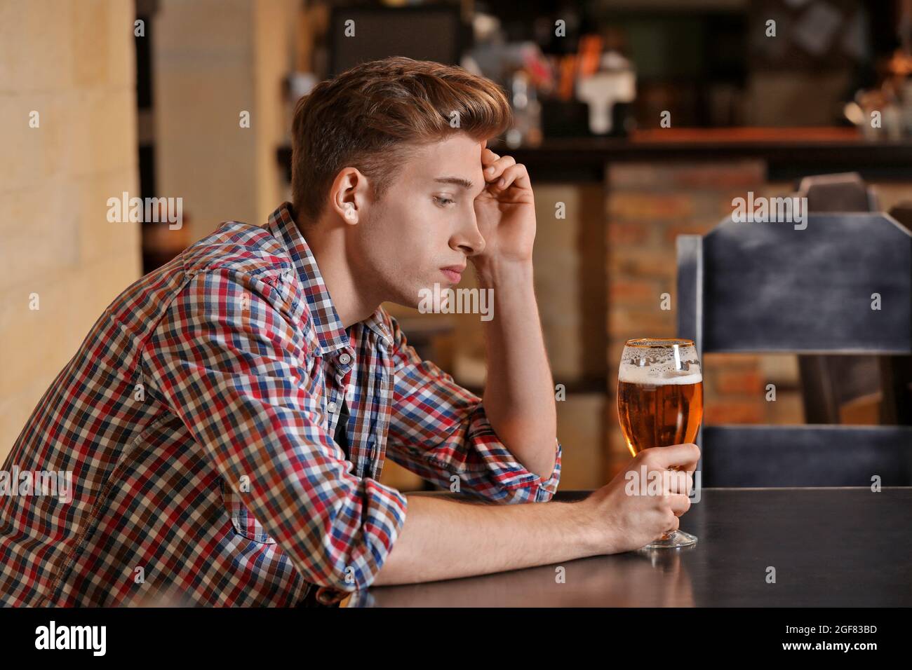 Young man sitting alone in a bar Stock Photo - Alamy
