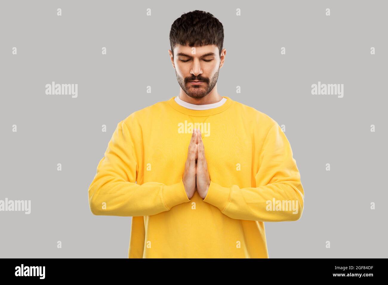 Man in yellow sweatshirt meditating hi-res stock photography and images ...