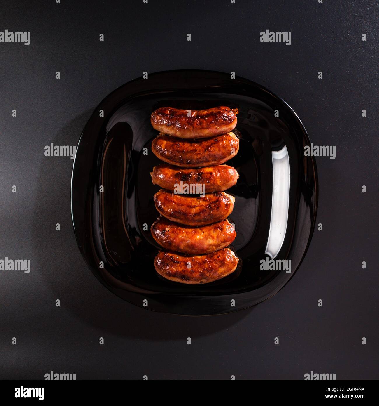 Grilled sausages top view on black background and on black plate Stock ...