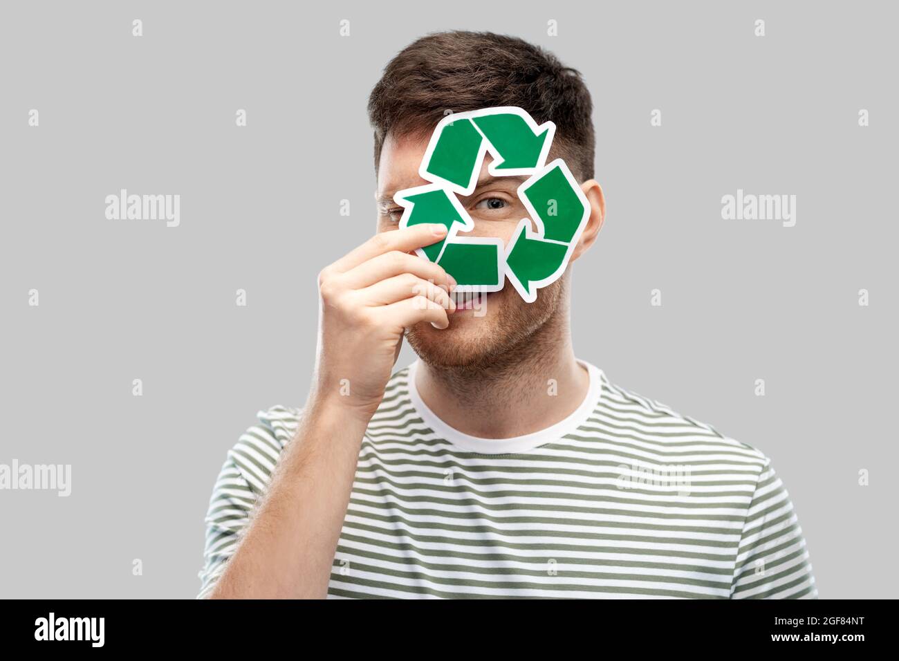 smiling young man holding green recycling sign Stock Photo - Alamy