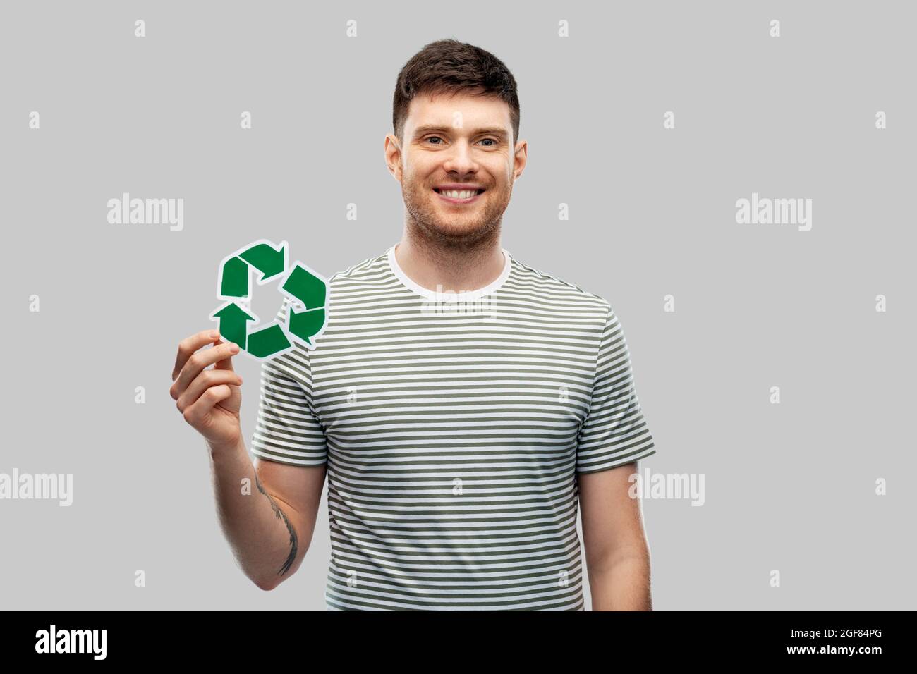 smiling young man holding green recycling sign Stock Photo - Alamy