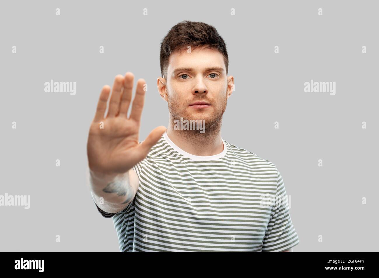 serious young man showing stop gesture Stock Photo - Alamy