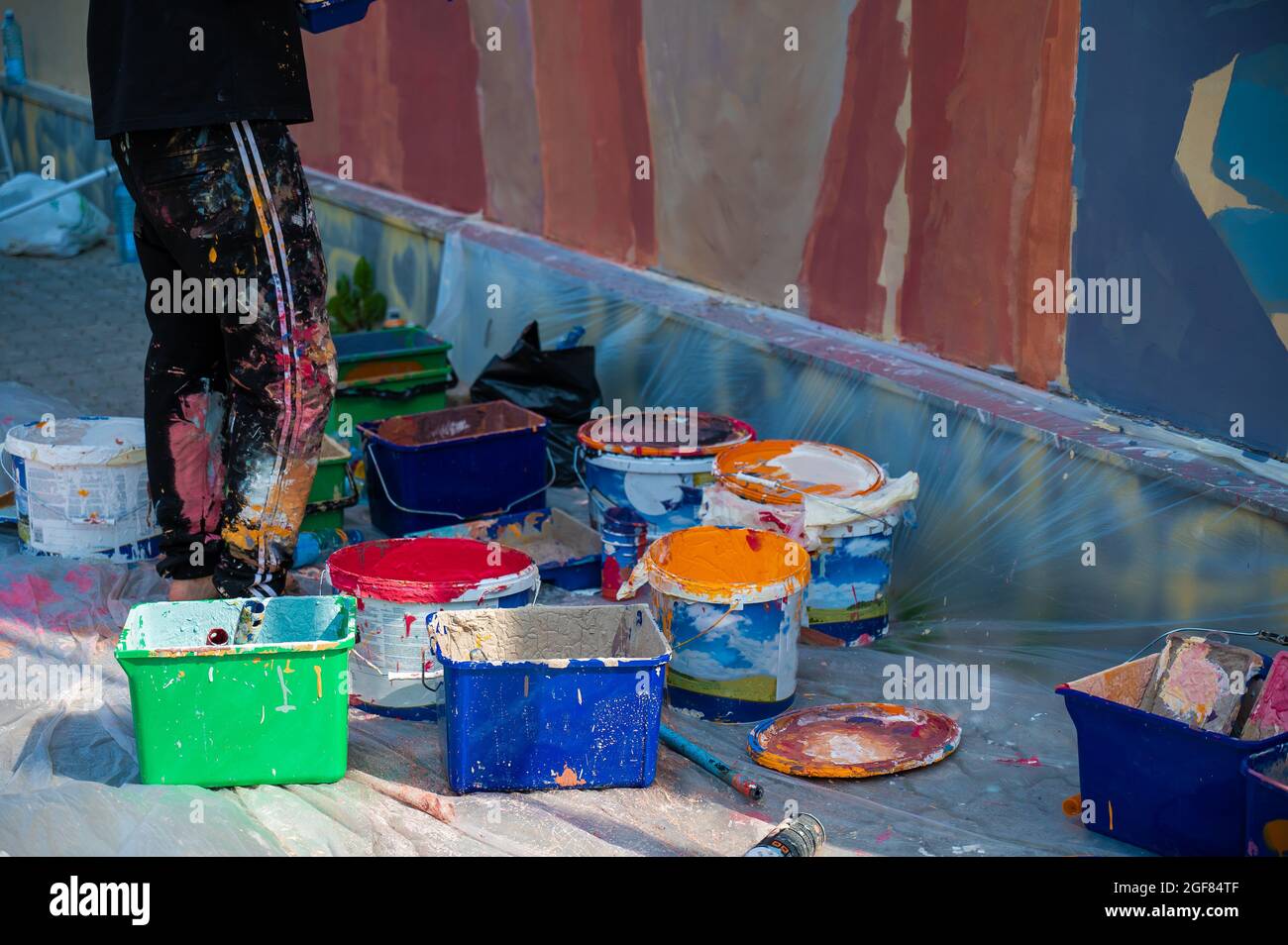 A street artist paints on the wall. close-up of paint buckets Stock ...