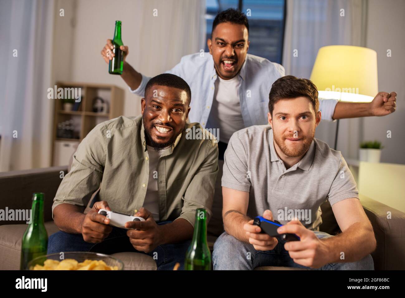 happy friends playing video games at home at night Stock Photo - Alamy