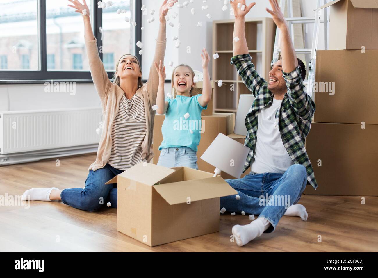 happy family playing with foam peanuts at new home Stock Photo - Alamy