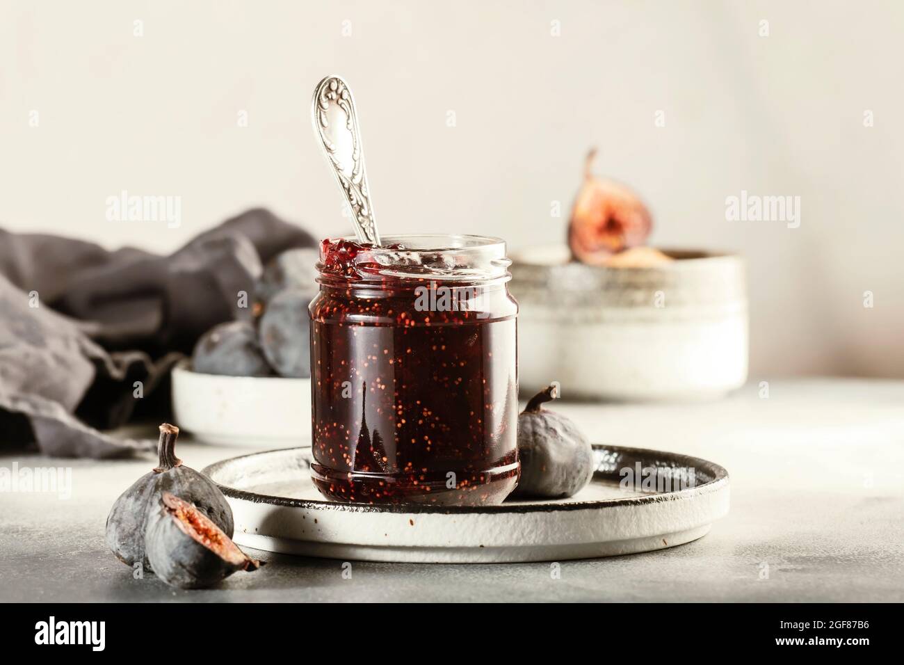 Fig confiture in glass jar. Fresh fruits on gray kitchen table ...