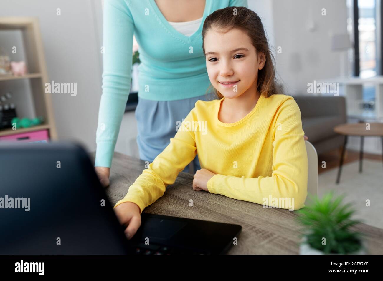 mother and daughter with laptop doing homework Stock Photo - Alamy