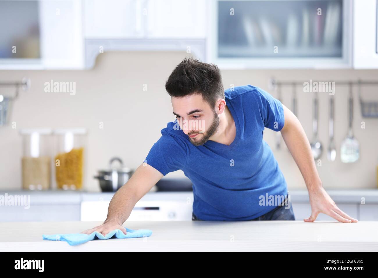 Man cleaning table in the kitchen Stock Photo - Alamy