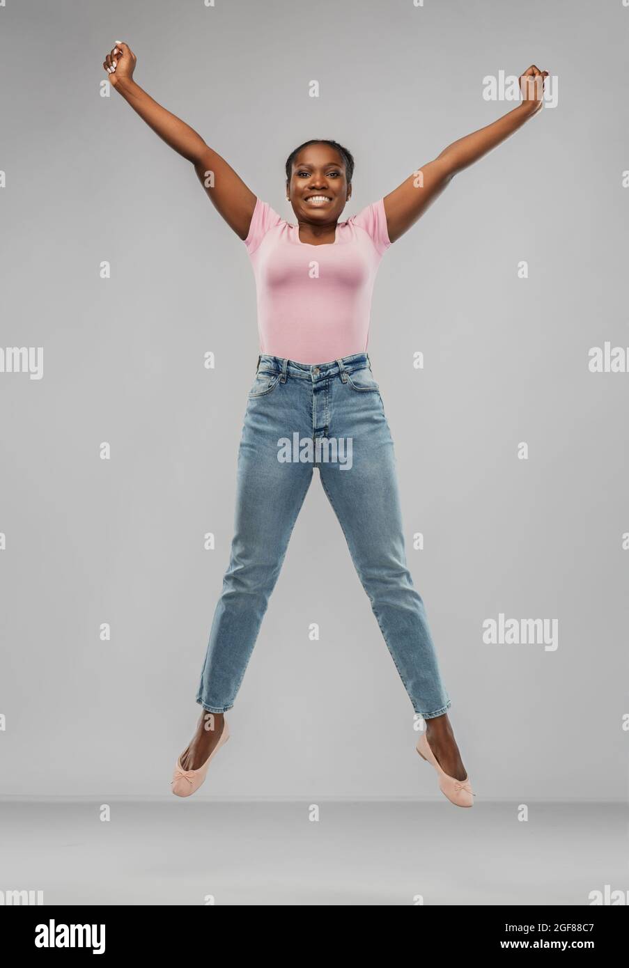 happy african american woman jumping over grey Stock Photo - Alamy