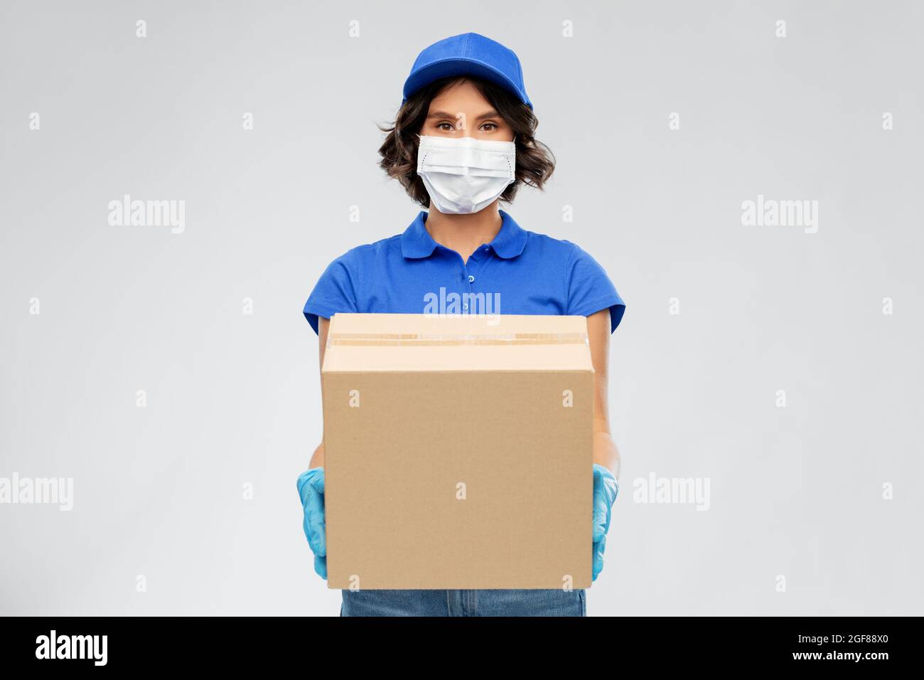 delivery woman in face mask holding parcel box Stock Photo - Alamy